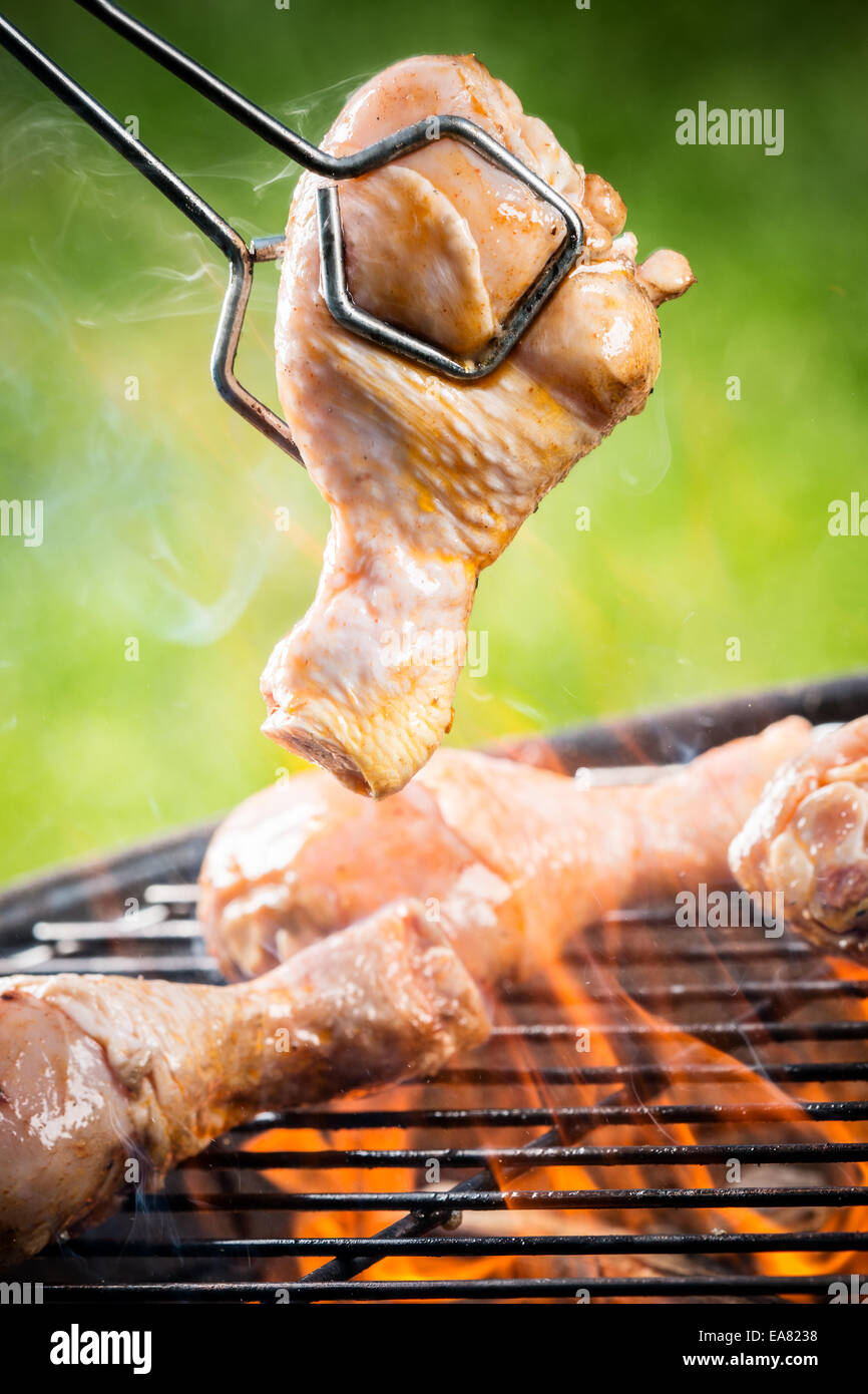 Chicken legs on barbecue grill with fire Stock Photo - Alamy