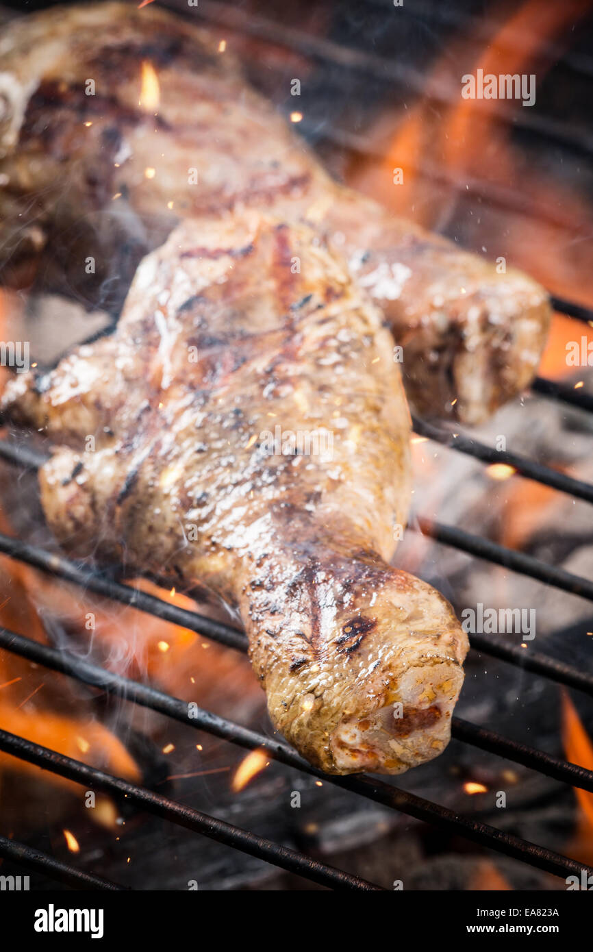 Chicken legs on barbecue grill with fire Stock Photo - Alamy