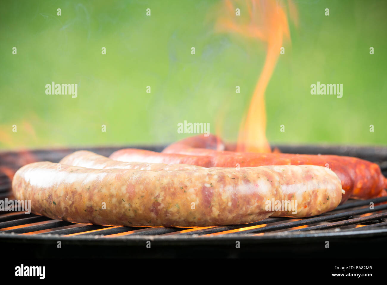 Delicious grilled sausages burning in fire Stock Photo - Alamy