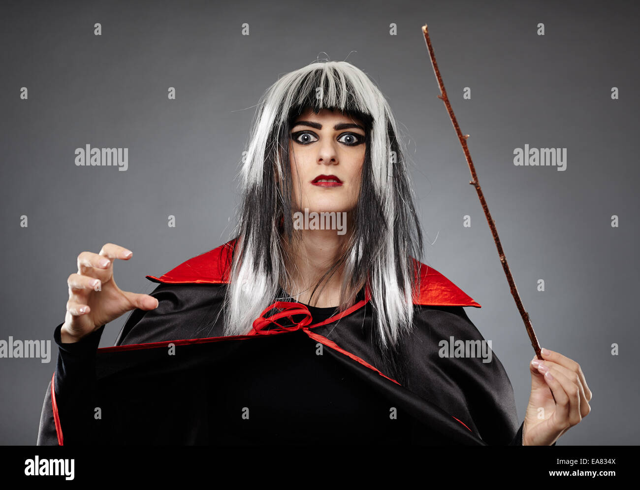 Young creepy witch making a spell with her wand, Halloween theme Stock ...