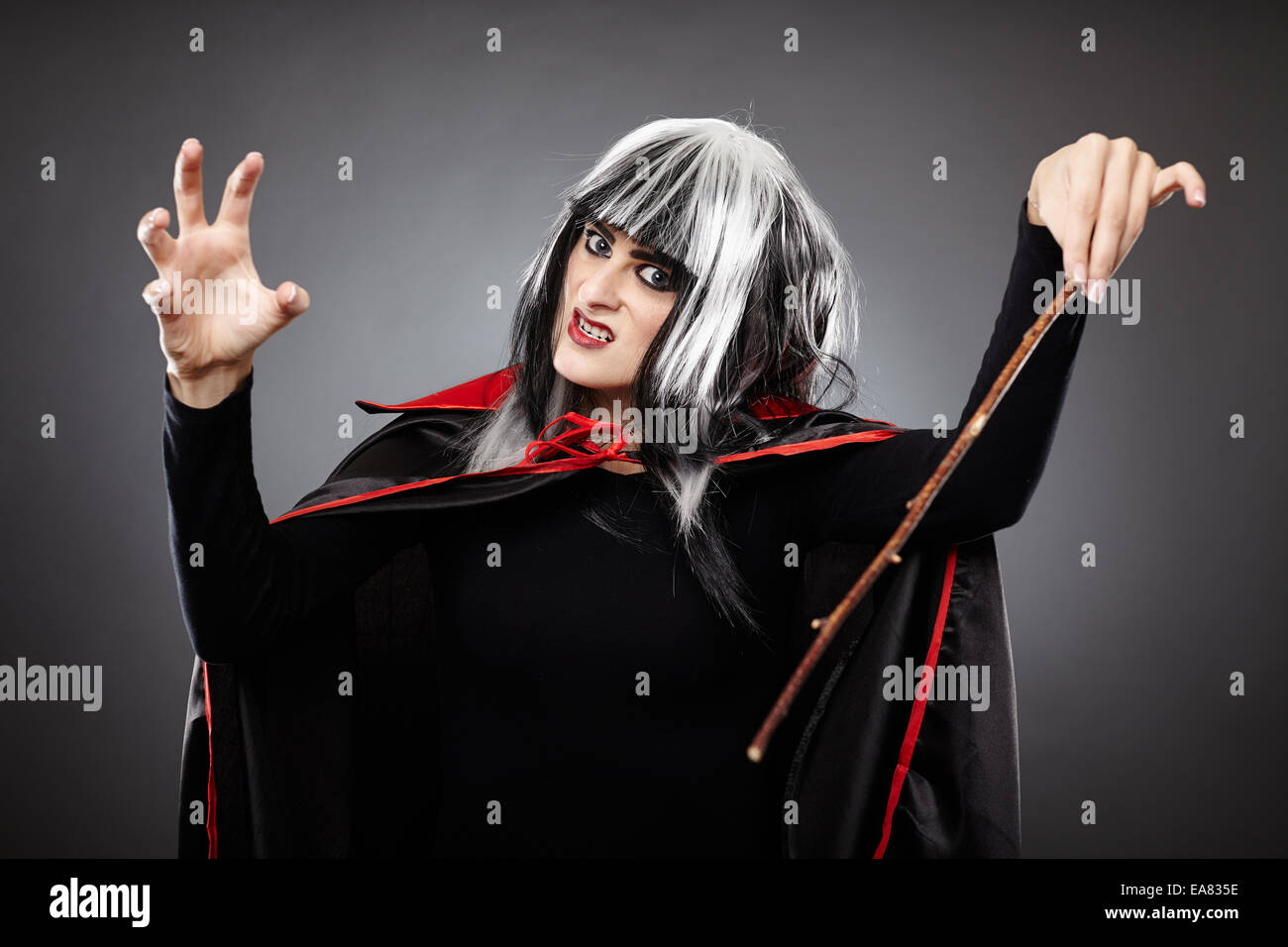 Young creepy witch making a spell with her wand, Halloween theme Stock ...