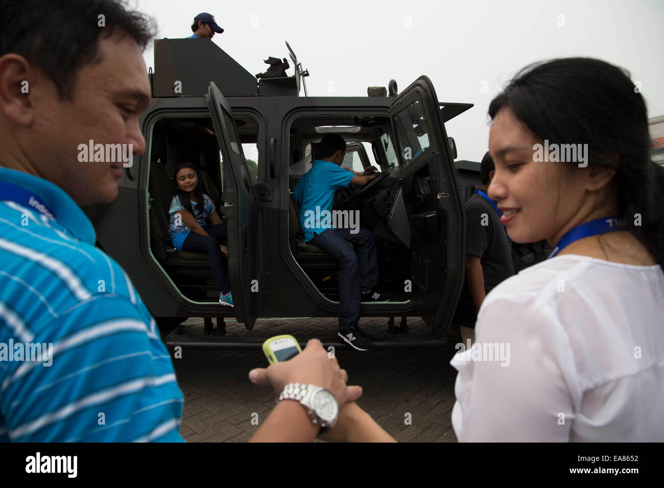 Couples exchange their cell phones before posed at an Indonesian Humvee ...