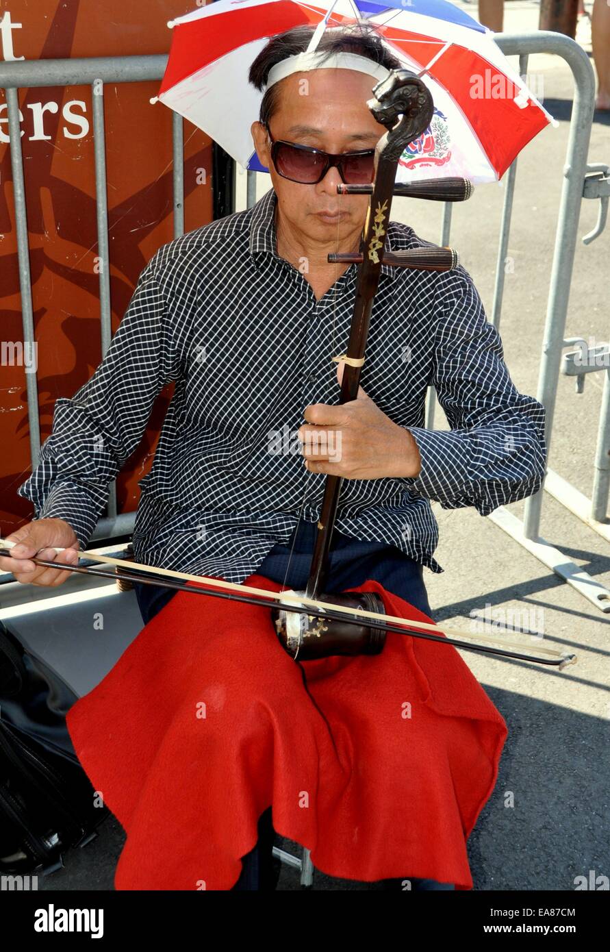 NYC: A Chinese man sporting a red, white, and blue umbrella hat playing ...