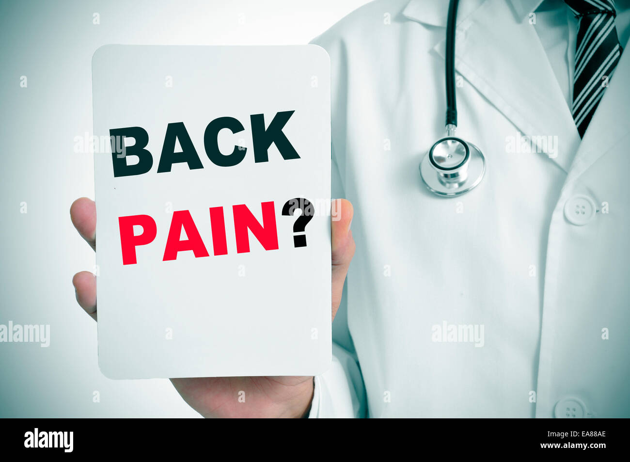a doctor showing a signboard with the question back pain? written in it ...