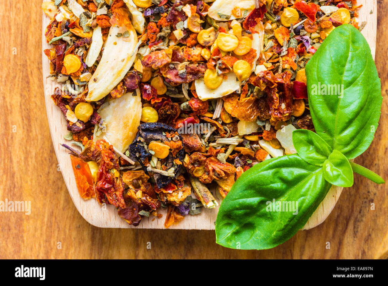 Good cuisine. Closeup colored spices for pasta mix and fresh basil leaf ...