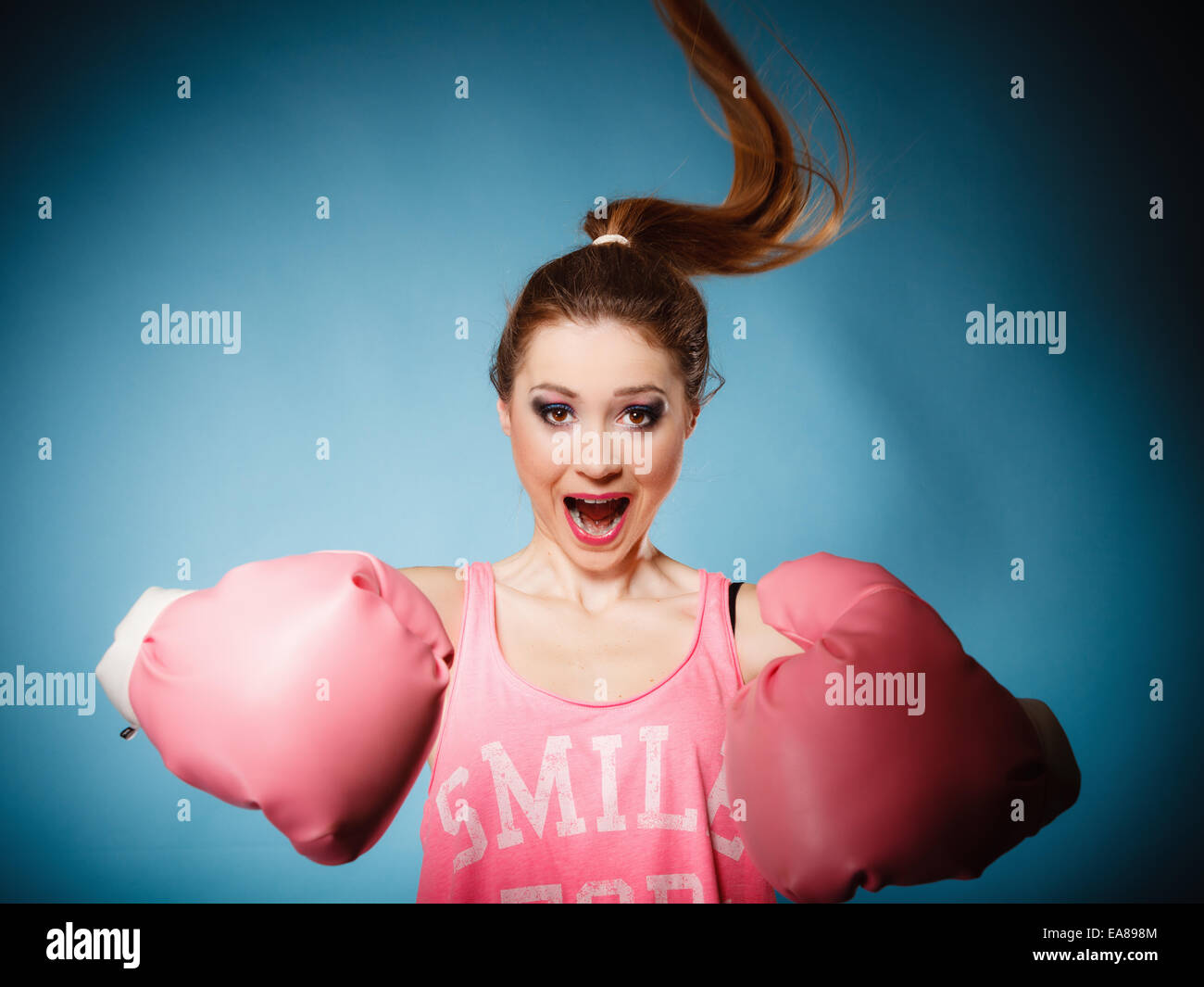 Funny girl female boxer in big fun pink gloves playing sports boxing ...