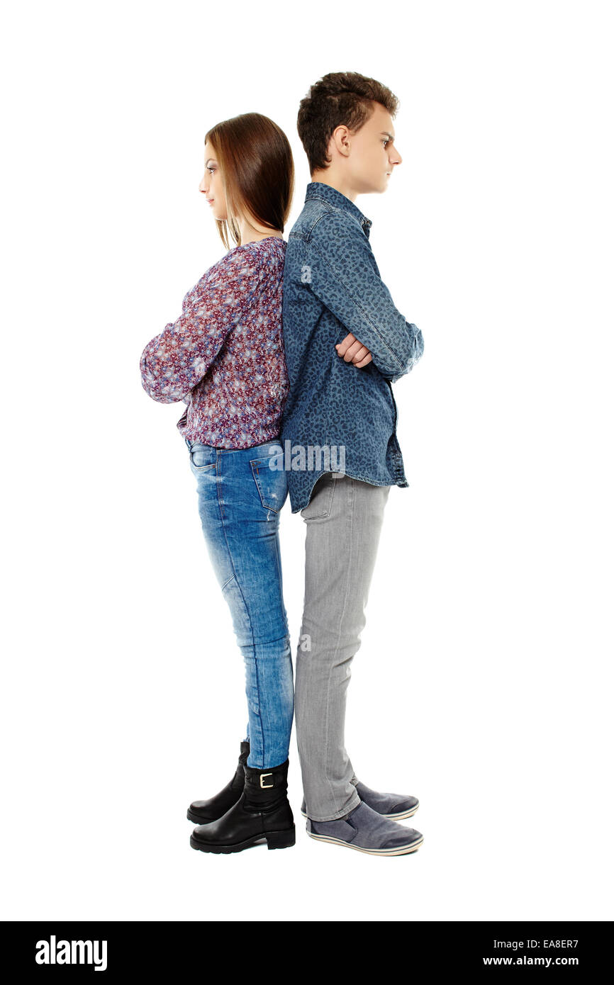 Two upset teenagers standing back to back isolated on white background ...
