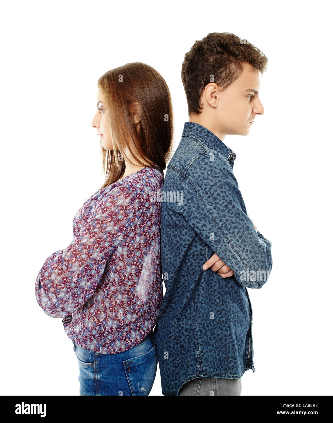 Two upset teenagers standing back to back isolated on white background ...