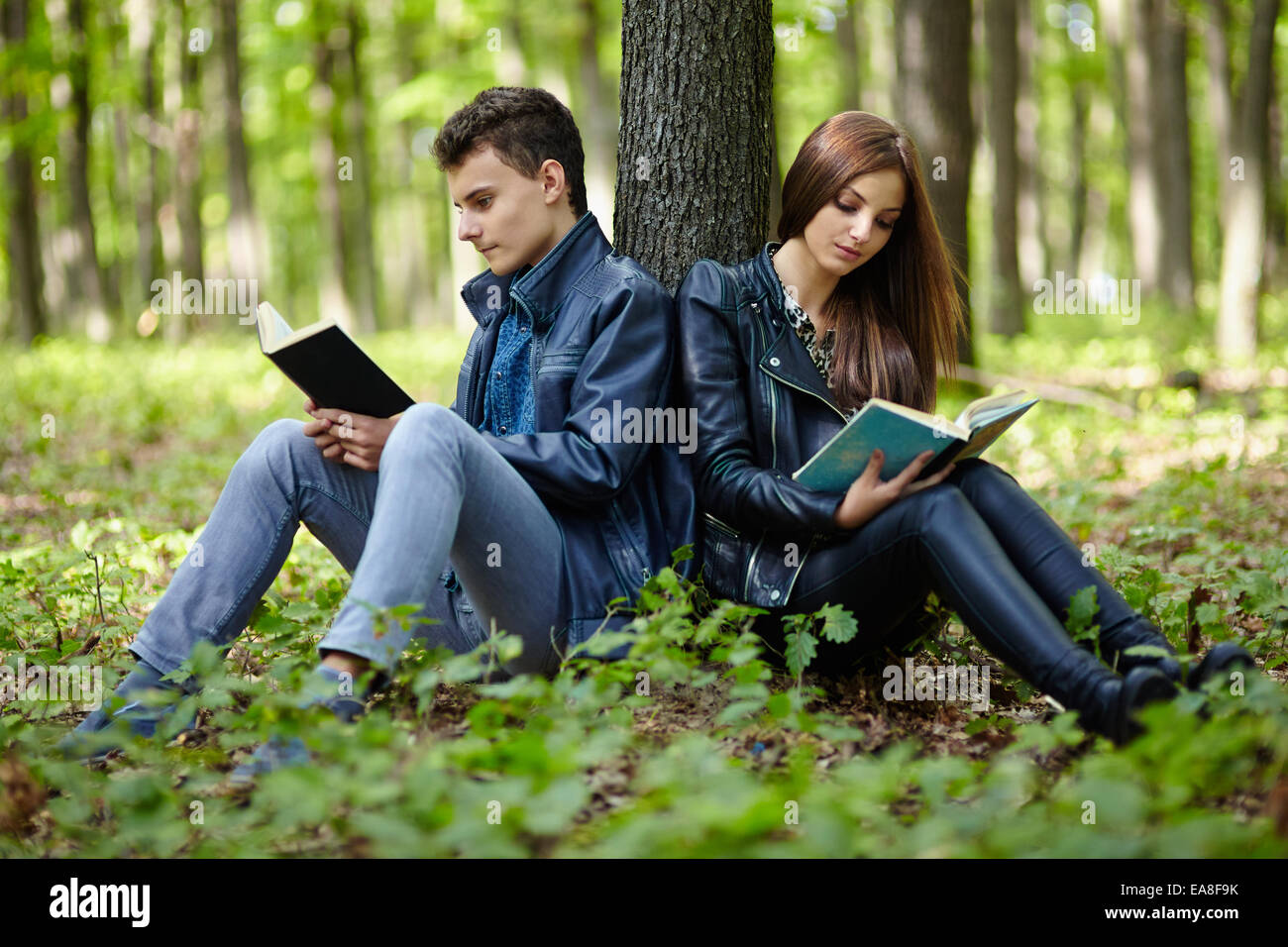 Teenagers students boy and girl reading outdoor in a forest Stock Photo ...