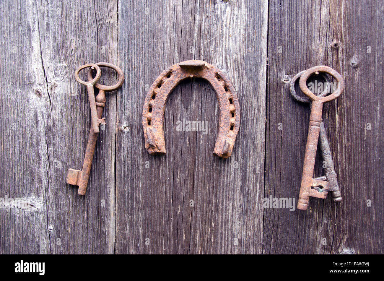 rusty ancient key and vintage horseshoe collection on old wooden barn ...