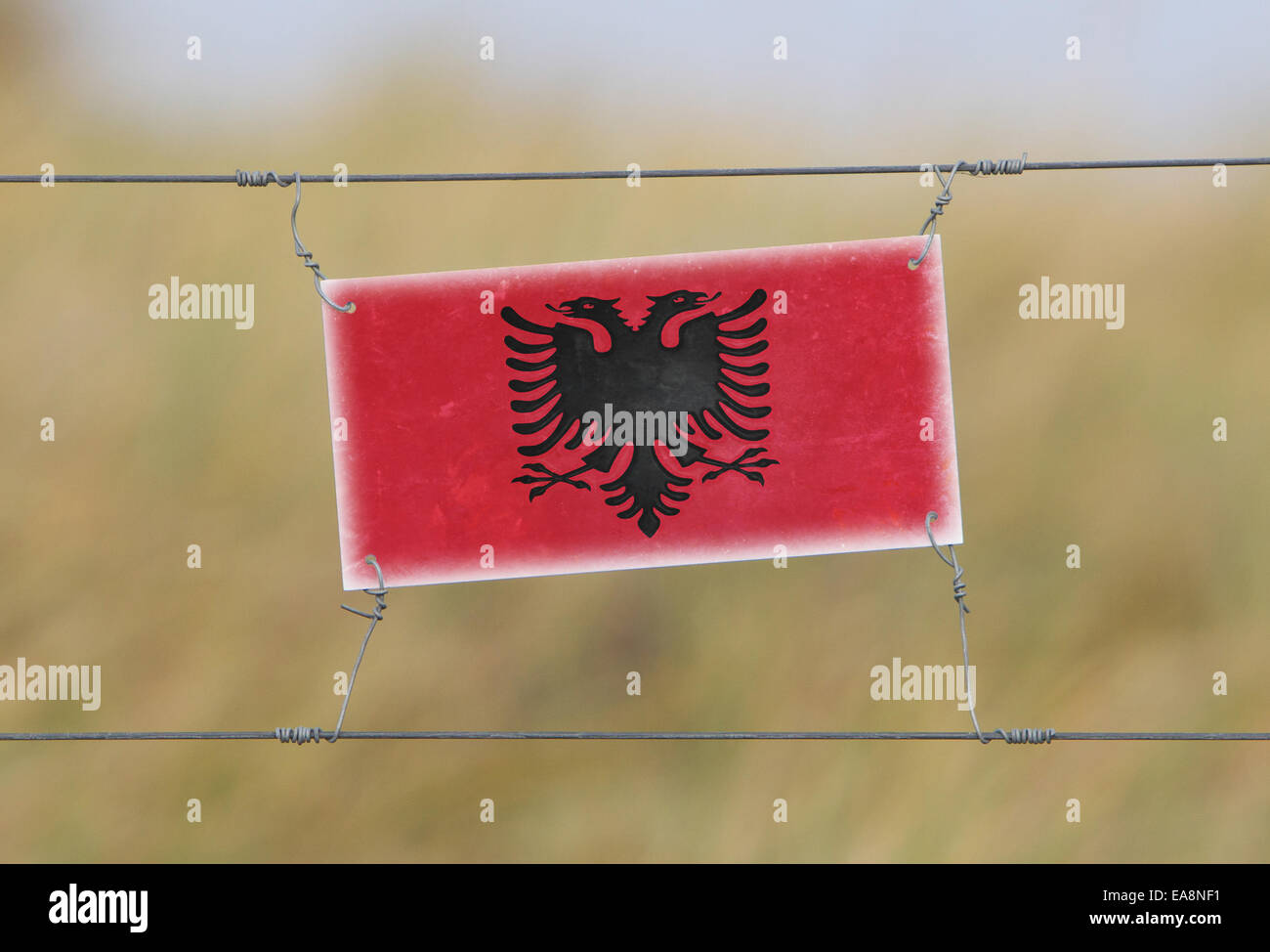 Border fence - Old plastic sign with a flag - Albania Stock Photo - Alamy