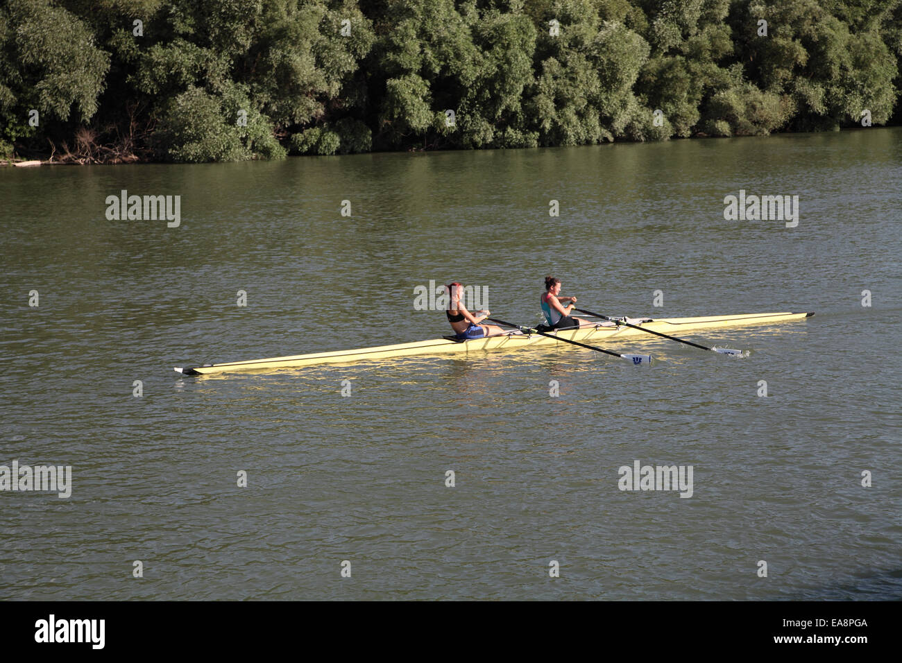 Two young women row a boat or skiff Stock Photo - Alamy