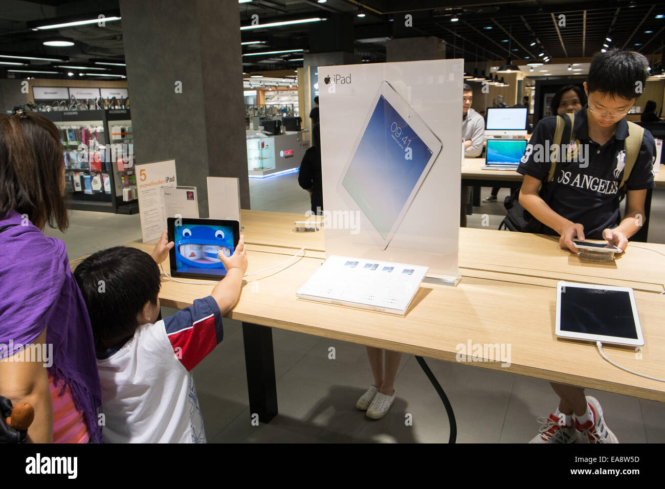 Girl using,testing,checking out an Apple ipad computer with her mother ...