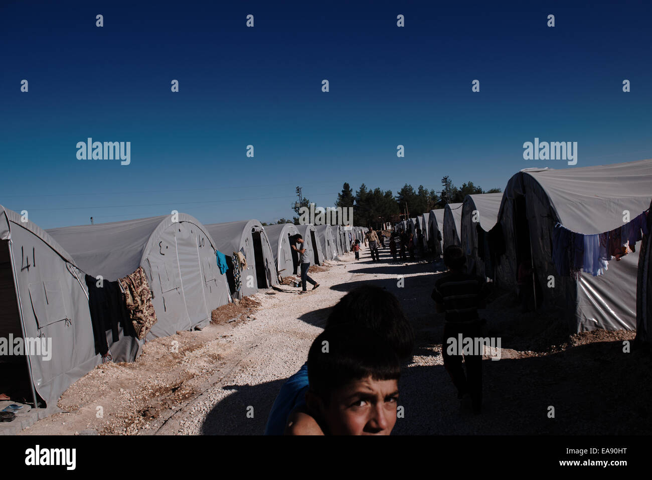 Kurdish boys walk inside a refugee camp in Suruc, Turkey Stock Photo ...