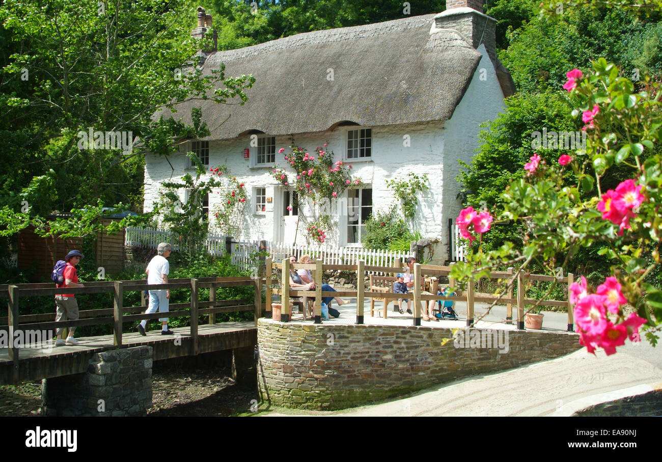 People walking across a footbridge in the pretty village of Helford on ...