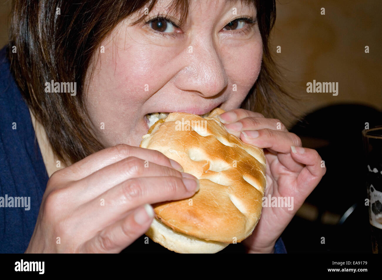 Hungry woman eating sandwich Stock Photo - Alamy