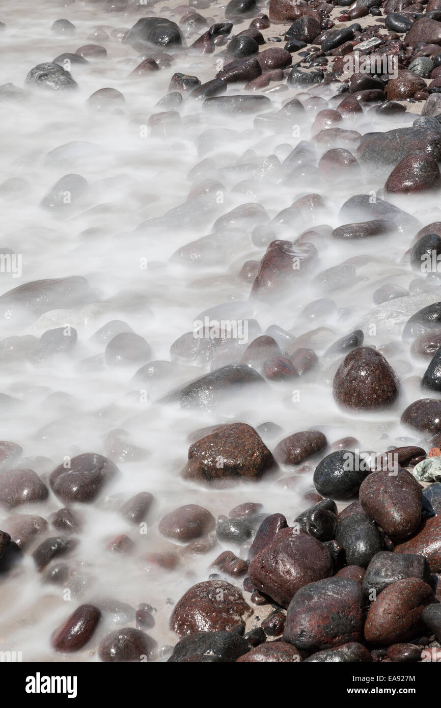 Sea washing over rocks on beach, long exposure Stock Photo - Alamy