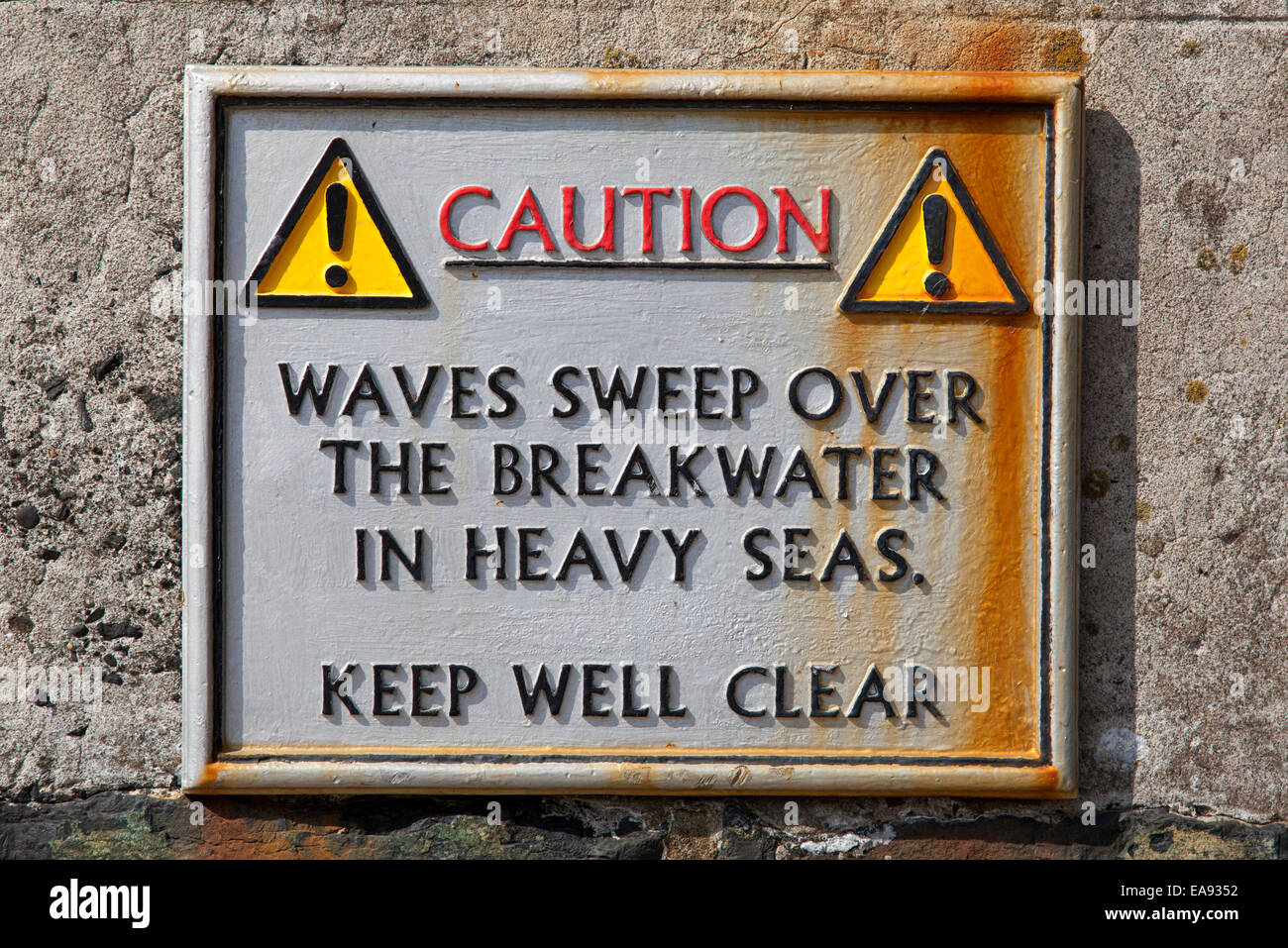 A warning sign on the harbour wall at Mullion, Cornwall, England, U.K ...