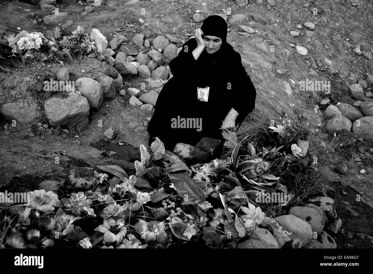 A mourner looks dejected next to a grave of a Kurdish fighter killed by ...