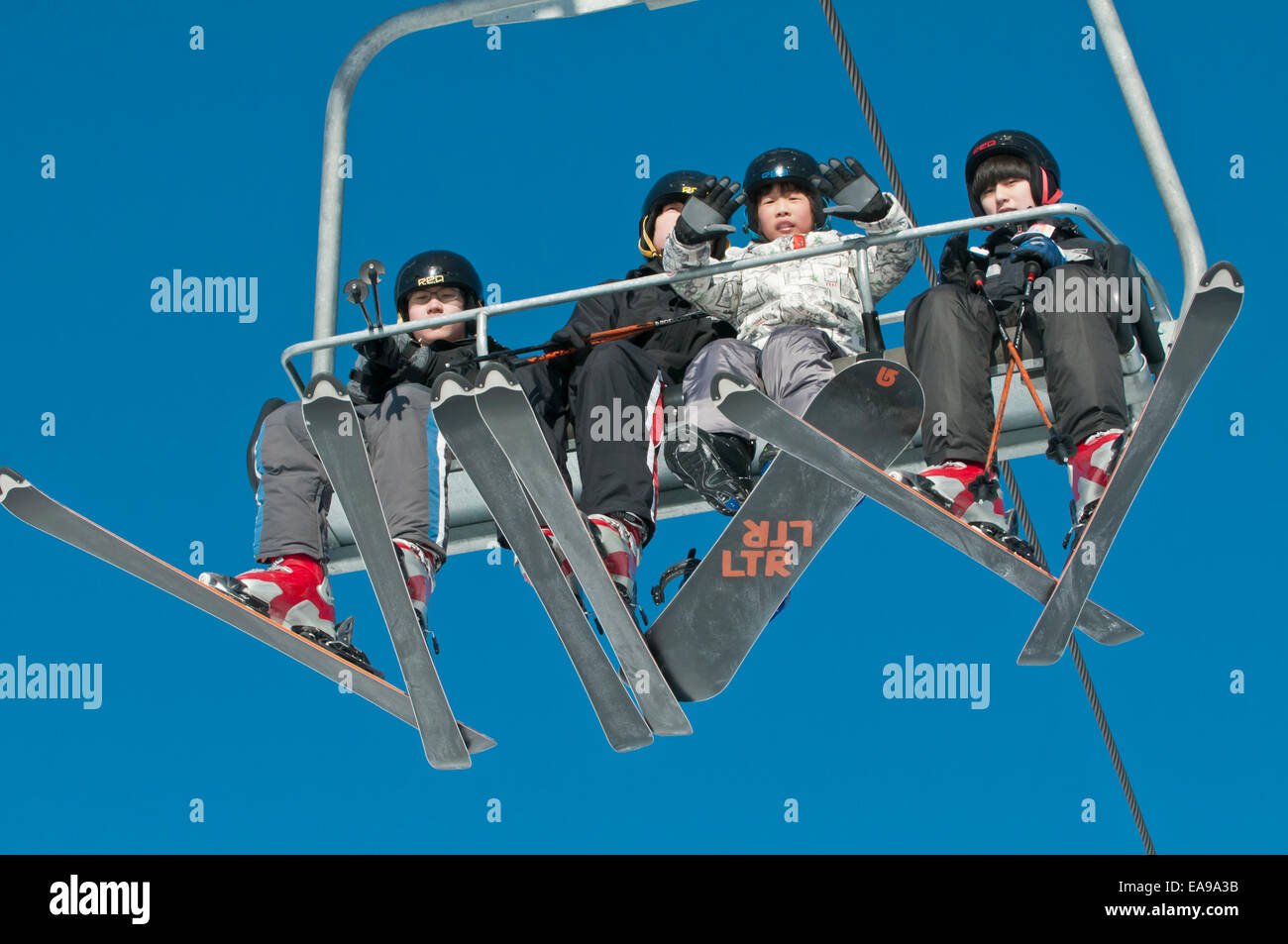 Asian skiiers and snowboarders on a ski lift, Canada Olympic Park, COP ...