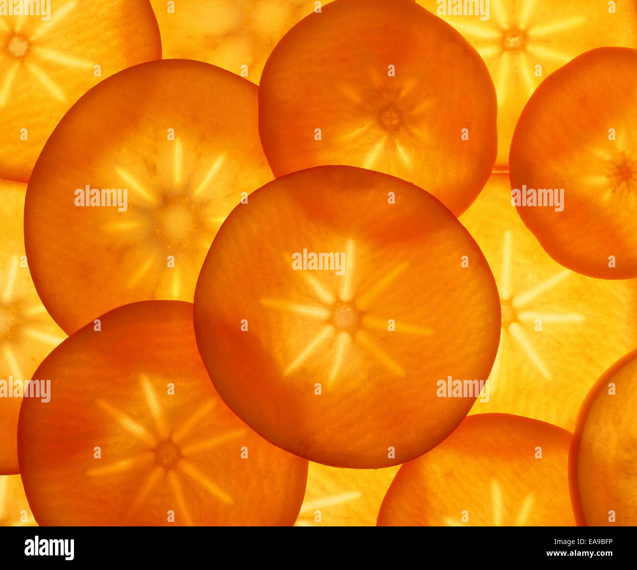 Ripe orange persimmon fruit slices as food background, top view Stock ...