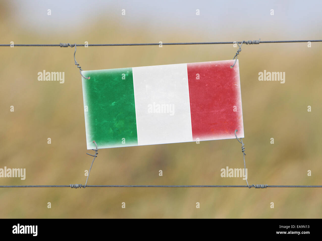 Border fence - Old plastic sign with a flag - Italy Stock Photo - Alamy