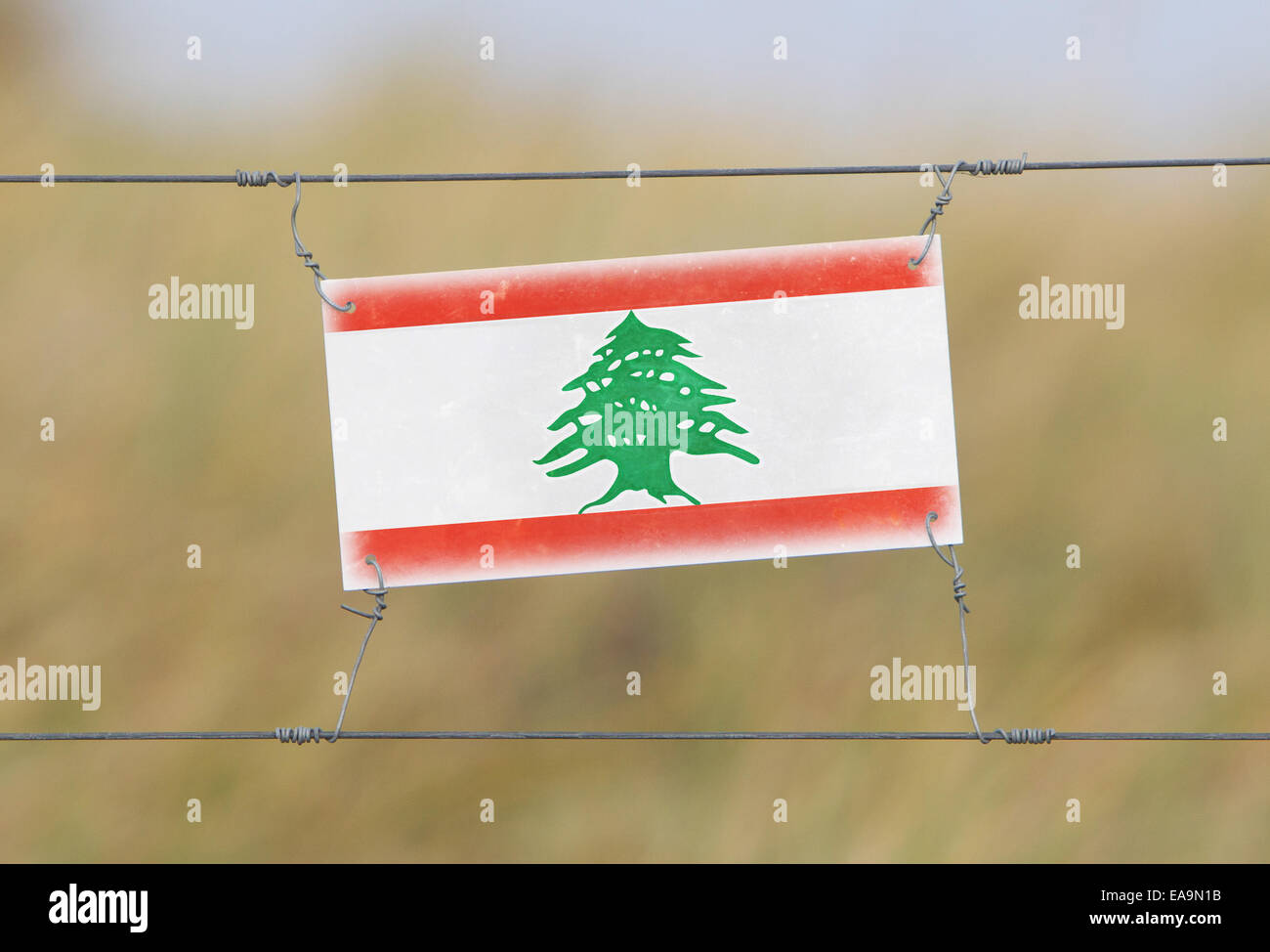 Border fence - Old plastic sign with a flag - Lebanon Stock Photo - Alamy