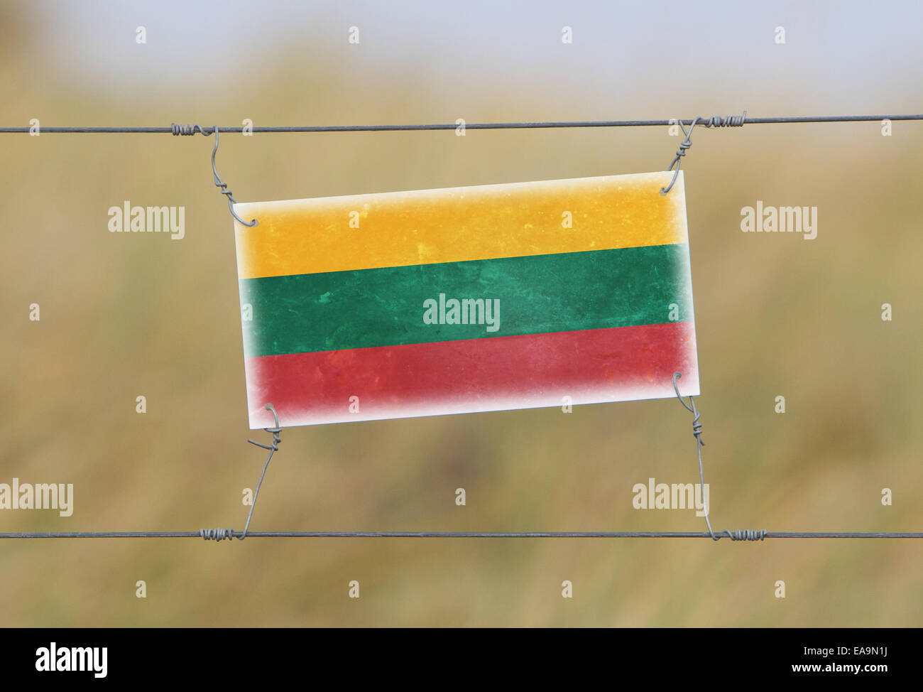 Border fence - Old plastic sign with a flag - Lithuania Stock Photo - Alamy