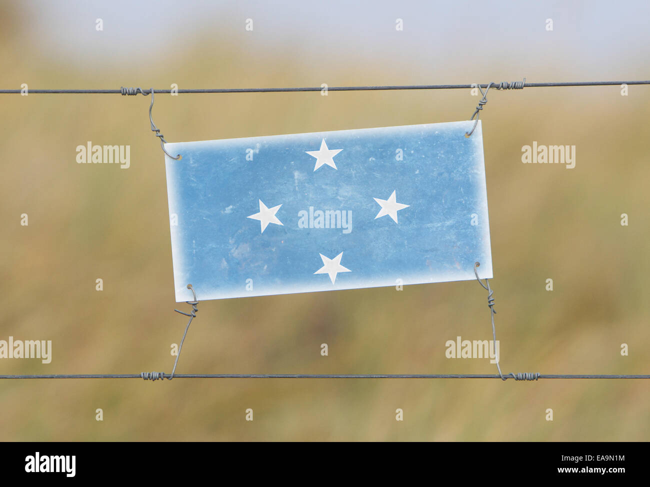 Border fence - Old plastic sign with a flag - Micronesia Stock Photo ...