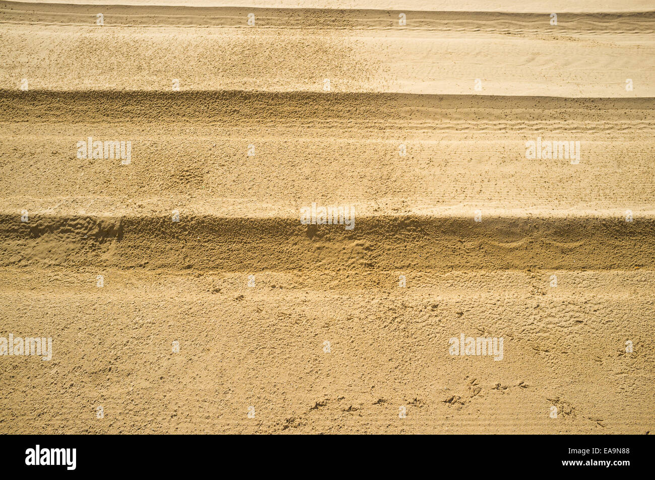 Different prints and marks on golden sand Stock Photo - Alamy