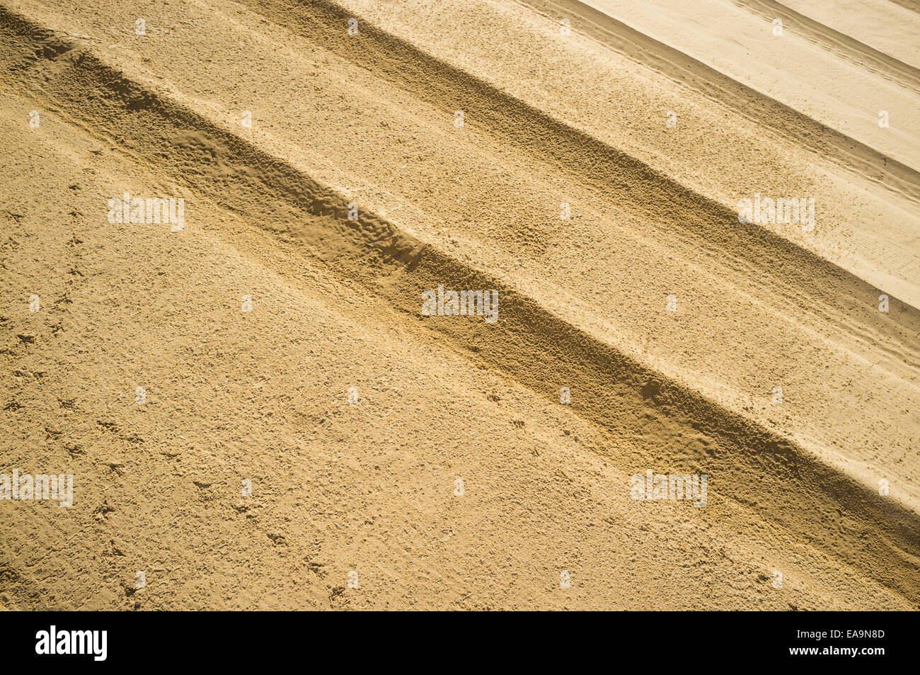 Different prints and marks on golden sand Stock Photo - Alamy