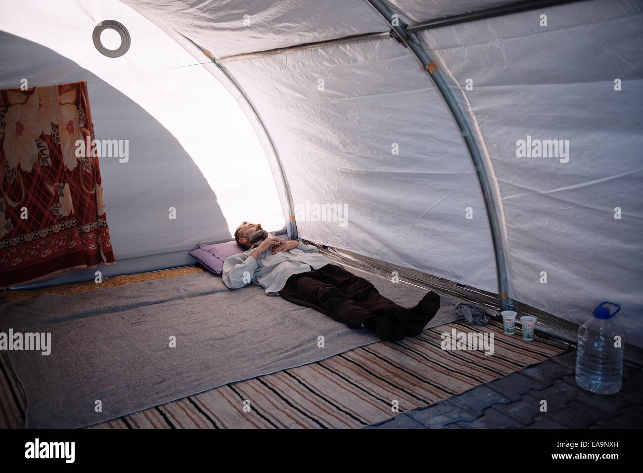 A Kurdish refugee from Kobani sleeps inside a tent in a refugee camp in ...
