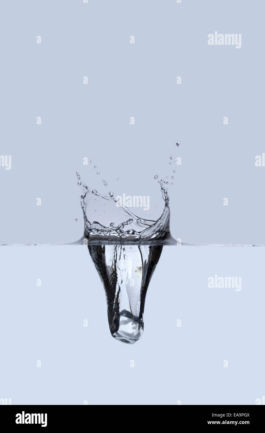 Ice cubes dropped into water Stock Photo - Alamy