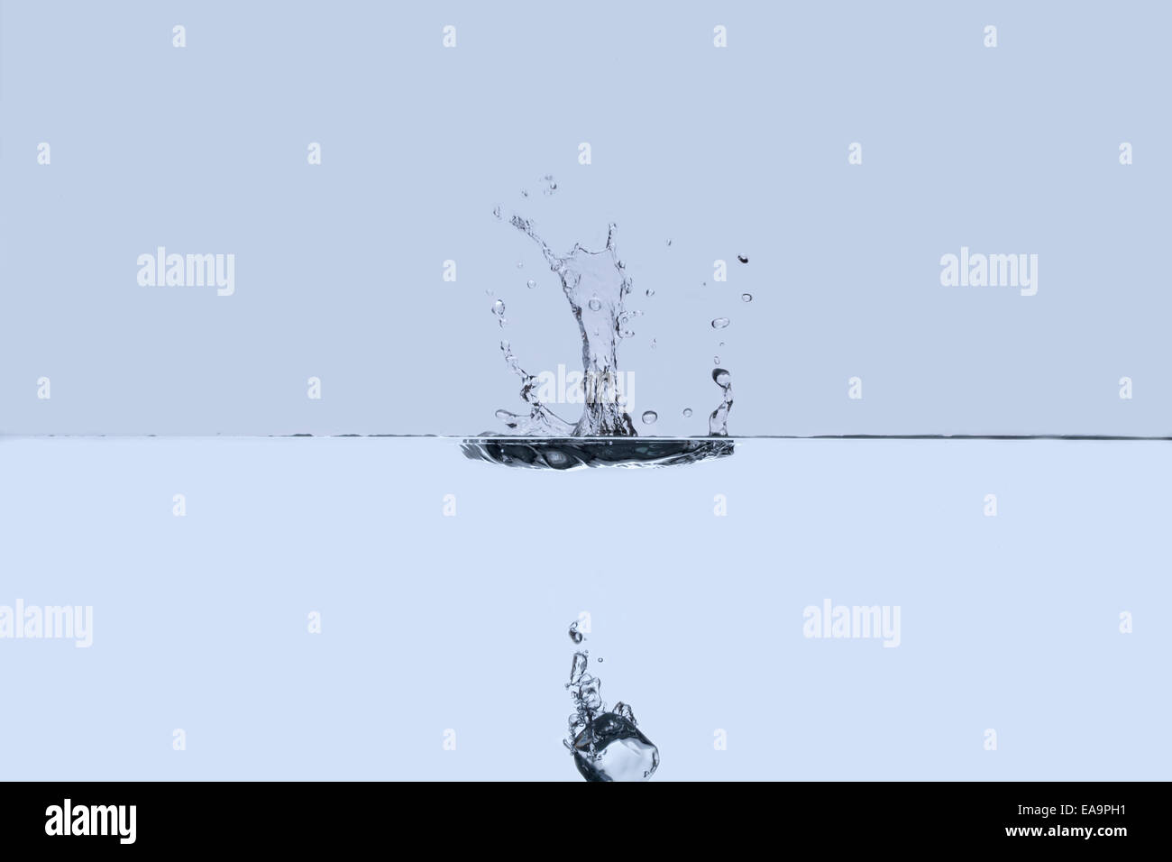 Ice cubes dropped into water Stock Photo - Alamy