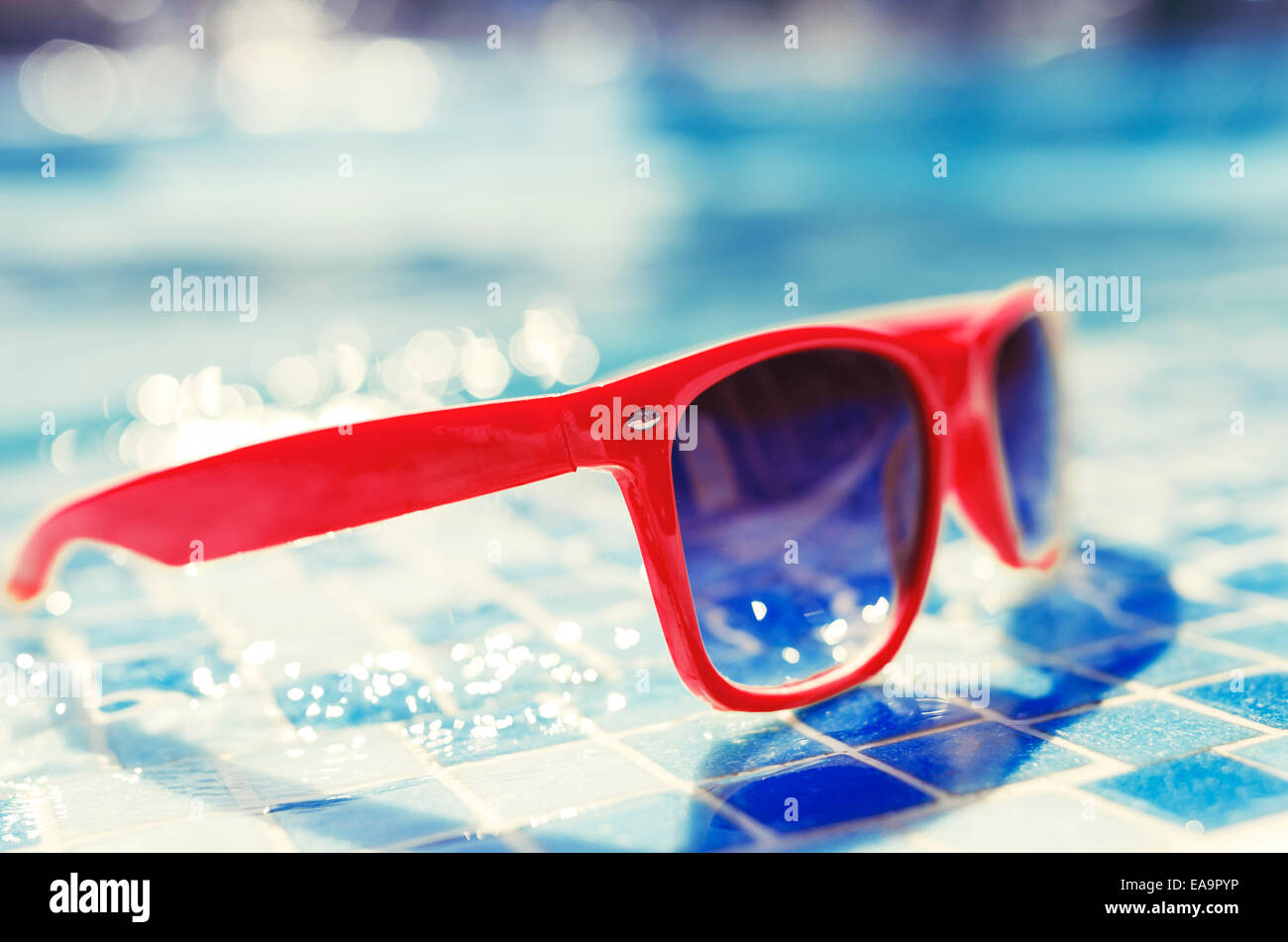 Sunglasses next to a pool Stock Photo - Alamy