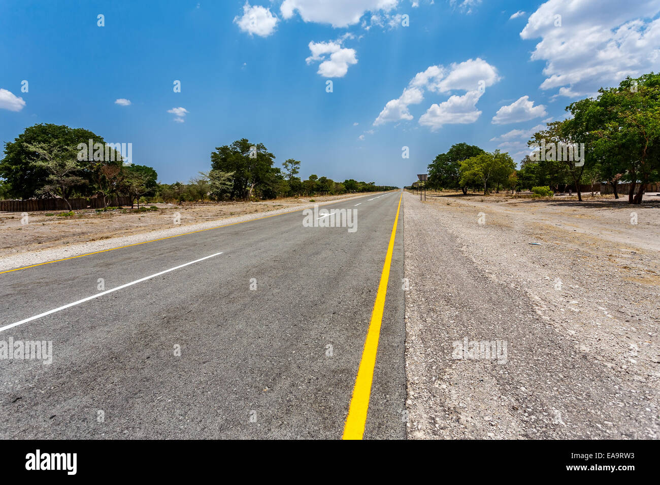 Endless road in Namibia, Caprivi Game Park, with blue sky Stock Photo ...