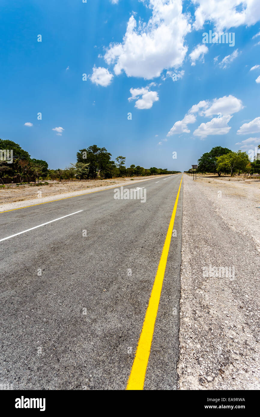 Endless road in Namibia, Caprivi Game Park, with blue sky Stock Photo ...