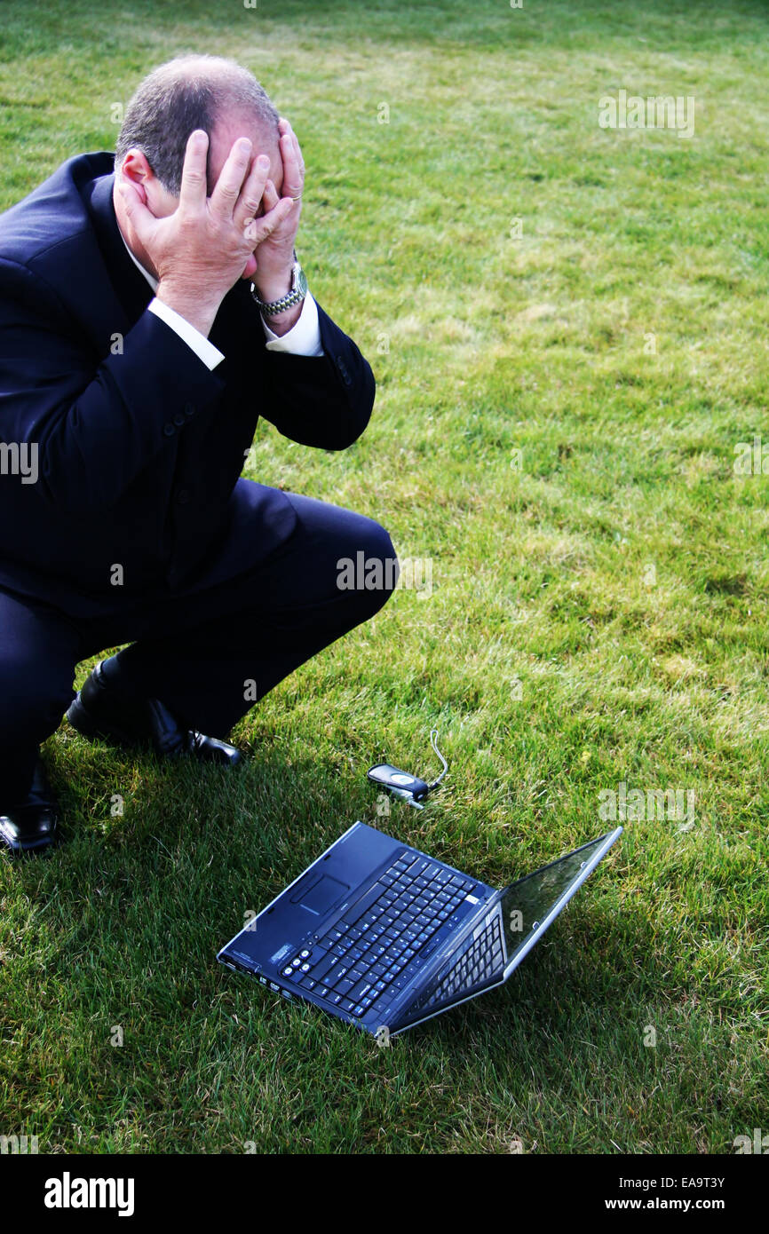Frustrated Business man outdoors in the grass Stock Photo - Alamy