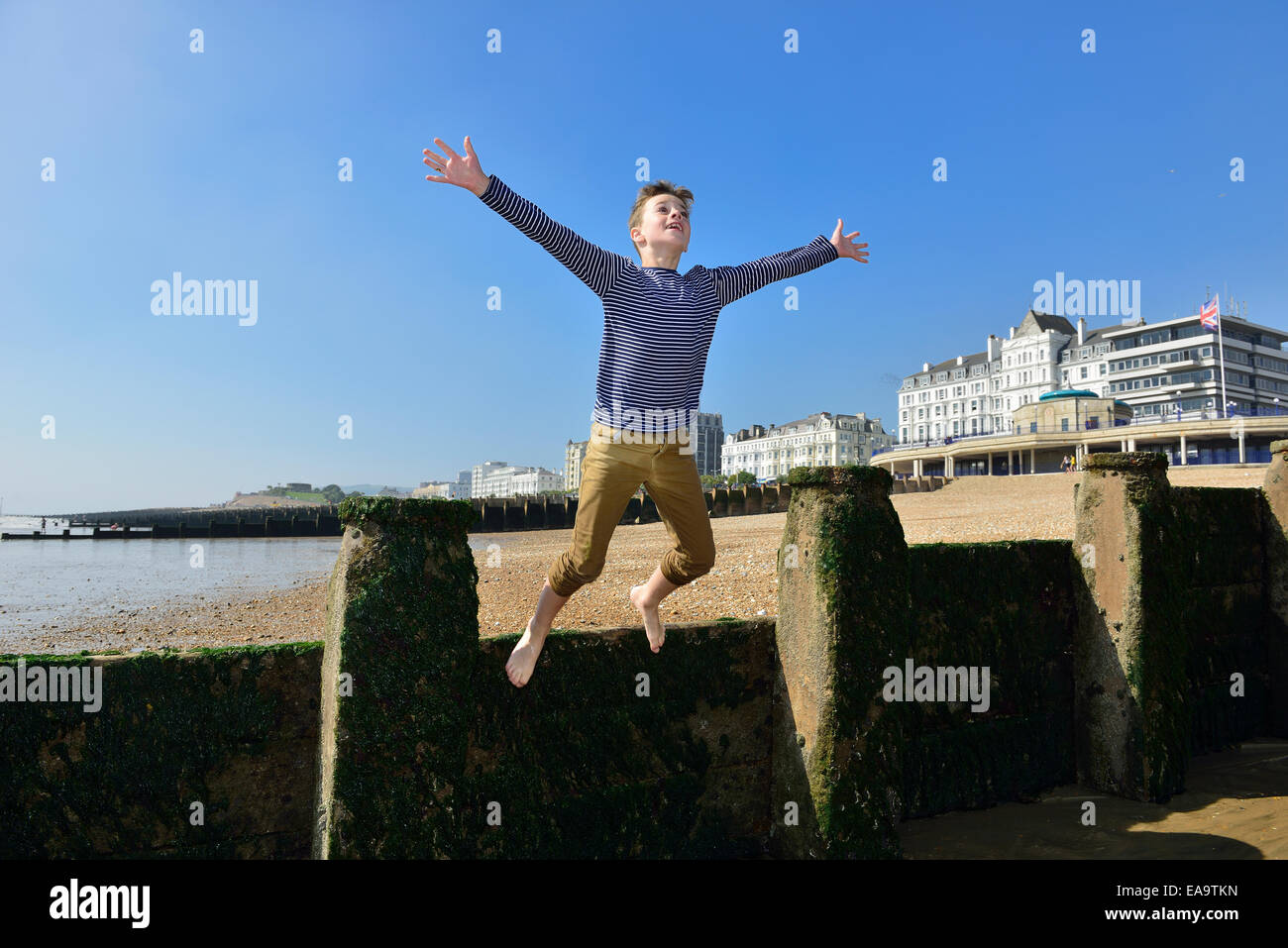 Boy jumping on beach. Eastbourne. East Sussex. UK Stock Photo - Alamy