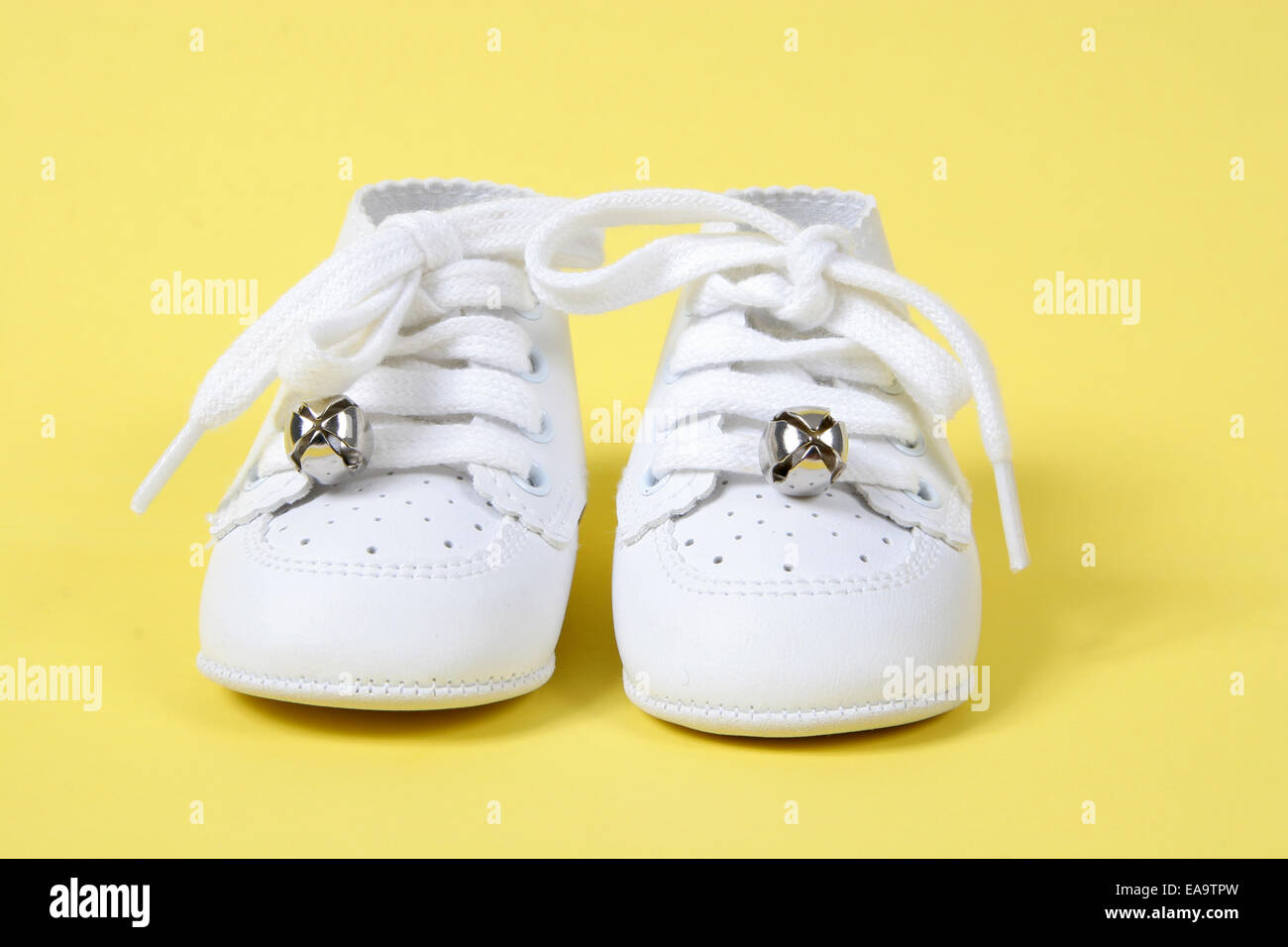 Little Baby shoes together on yellow background Stock Photo - Alamy