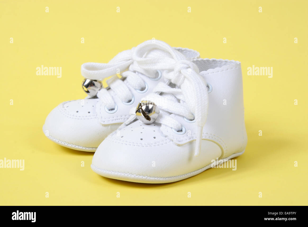 Small Baby shoes together on yellow background Stock Photo - Alamy