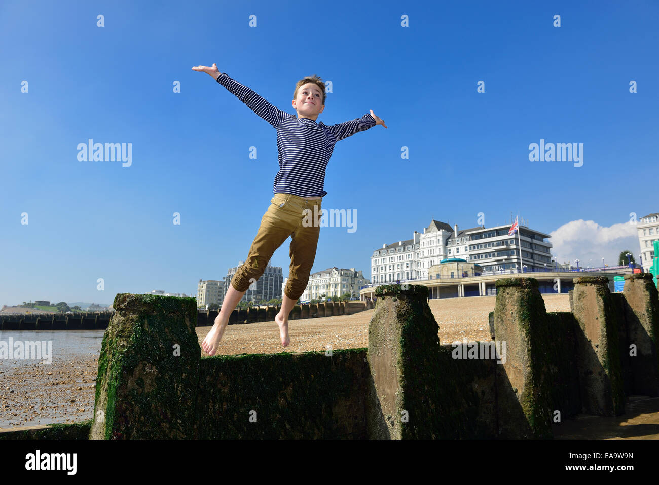 Boy jumping on beach. Eastbourne. East Sussex. UK Stock Photo - Alamy