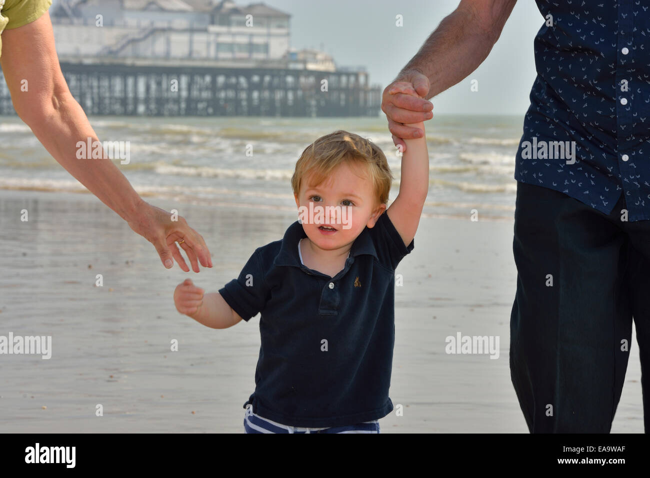 Little boy walking hand in hand with his grandparents. Eastbourne. East ...