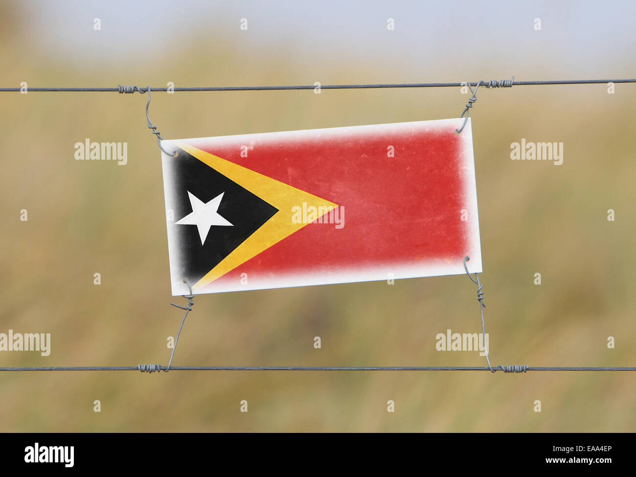 Border fence - Old plastic sign with a flag - East Timor Stock Photo ...