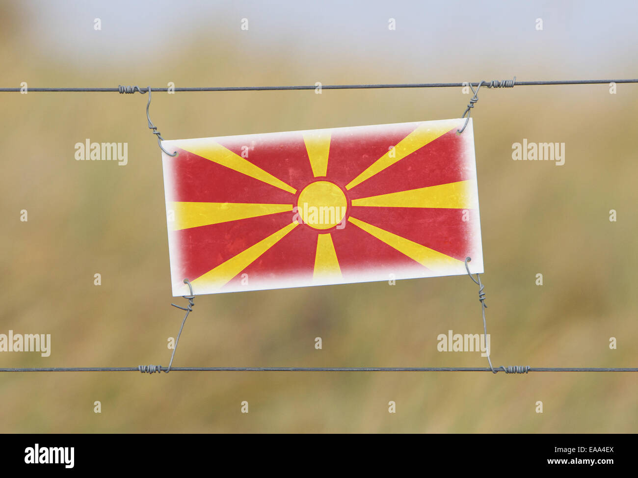 Border fence - Old plastic sign with a flag - Macedonia Stock Photo - Alamy