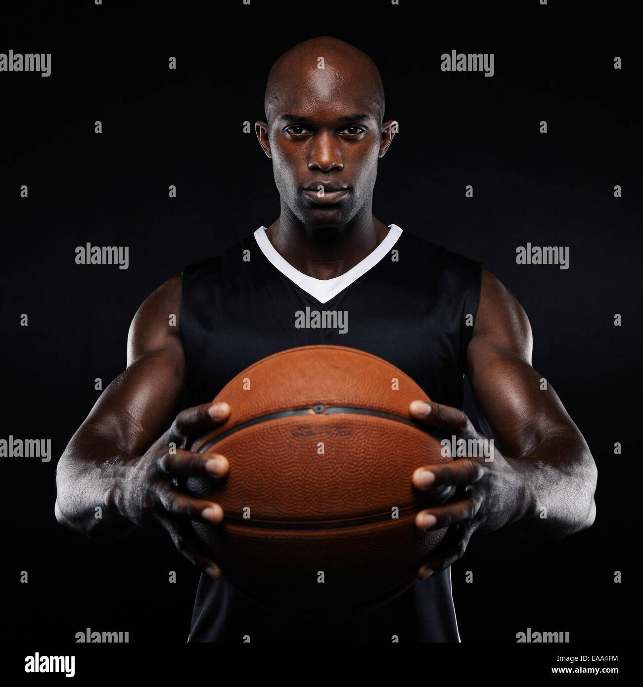 Portrait of muscular young male basketball player with a basketball ...