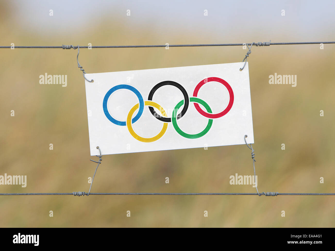 Border fence - Old plastic sign with a flag - Olympic rings Stock Photo ...
