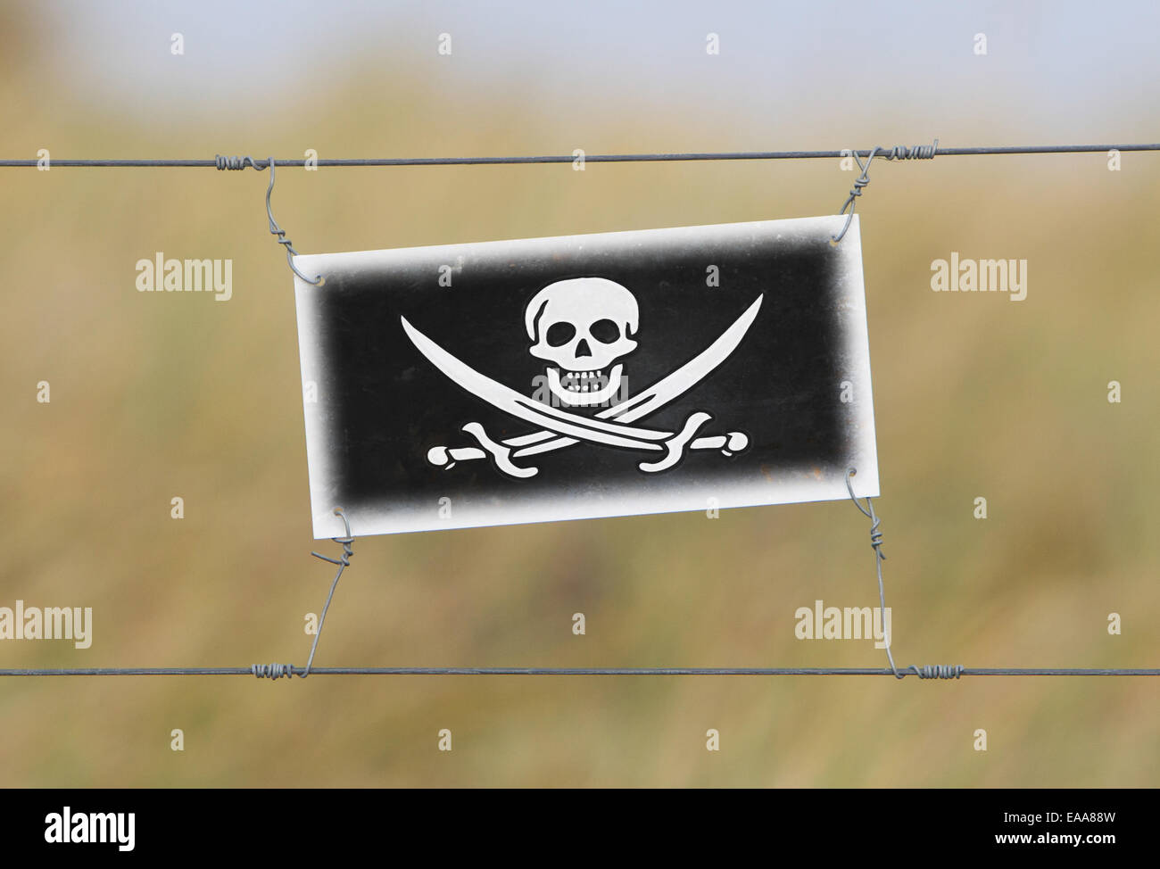 Border fence - Old plastic sign with a flag - Pirate Stock Photo - Alamy