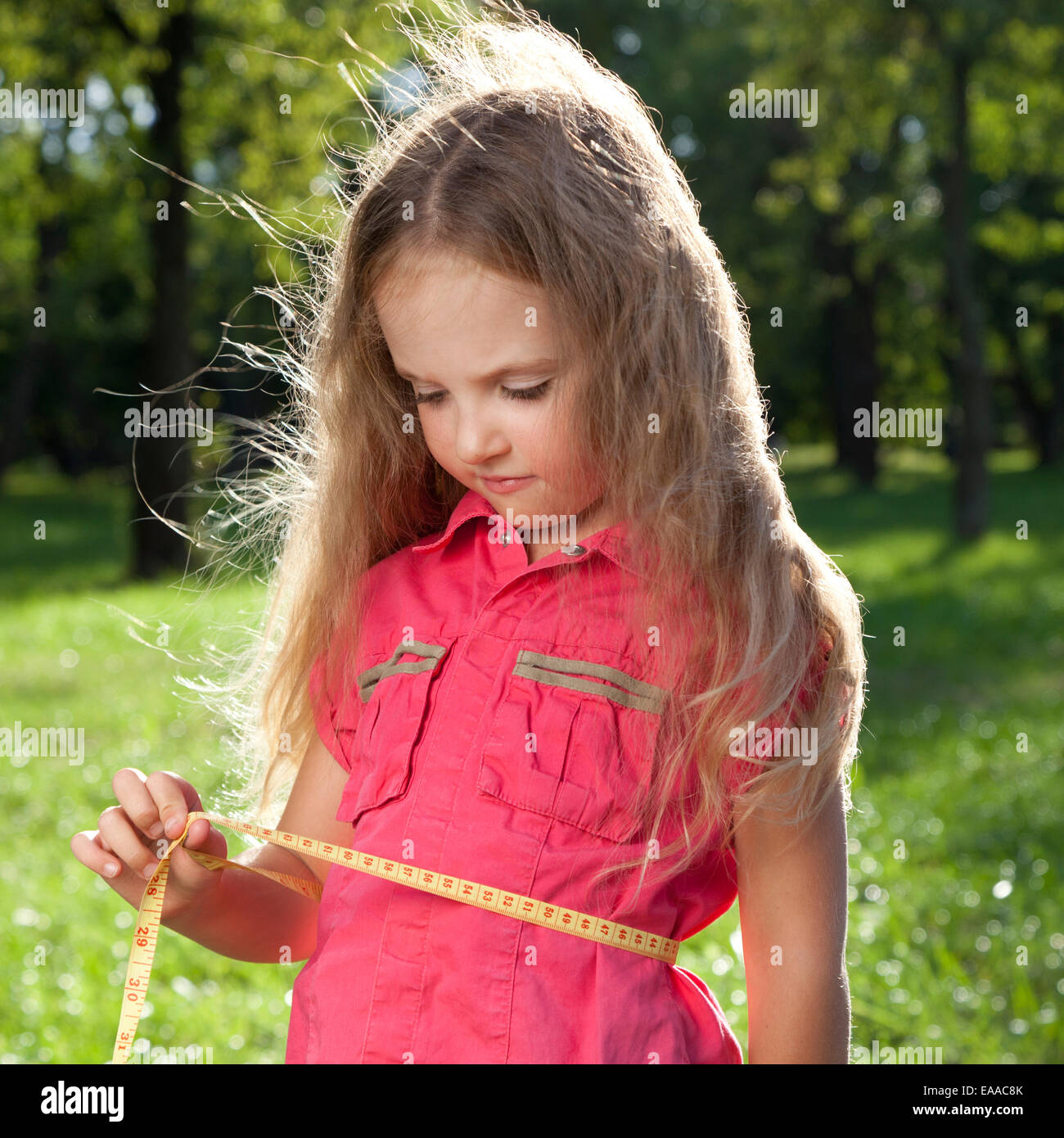 little girl measuring her her waistline Stock Photo - Alamy