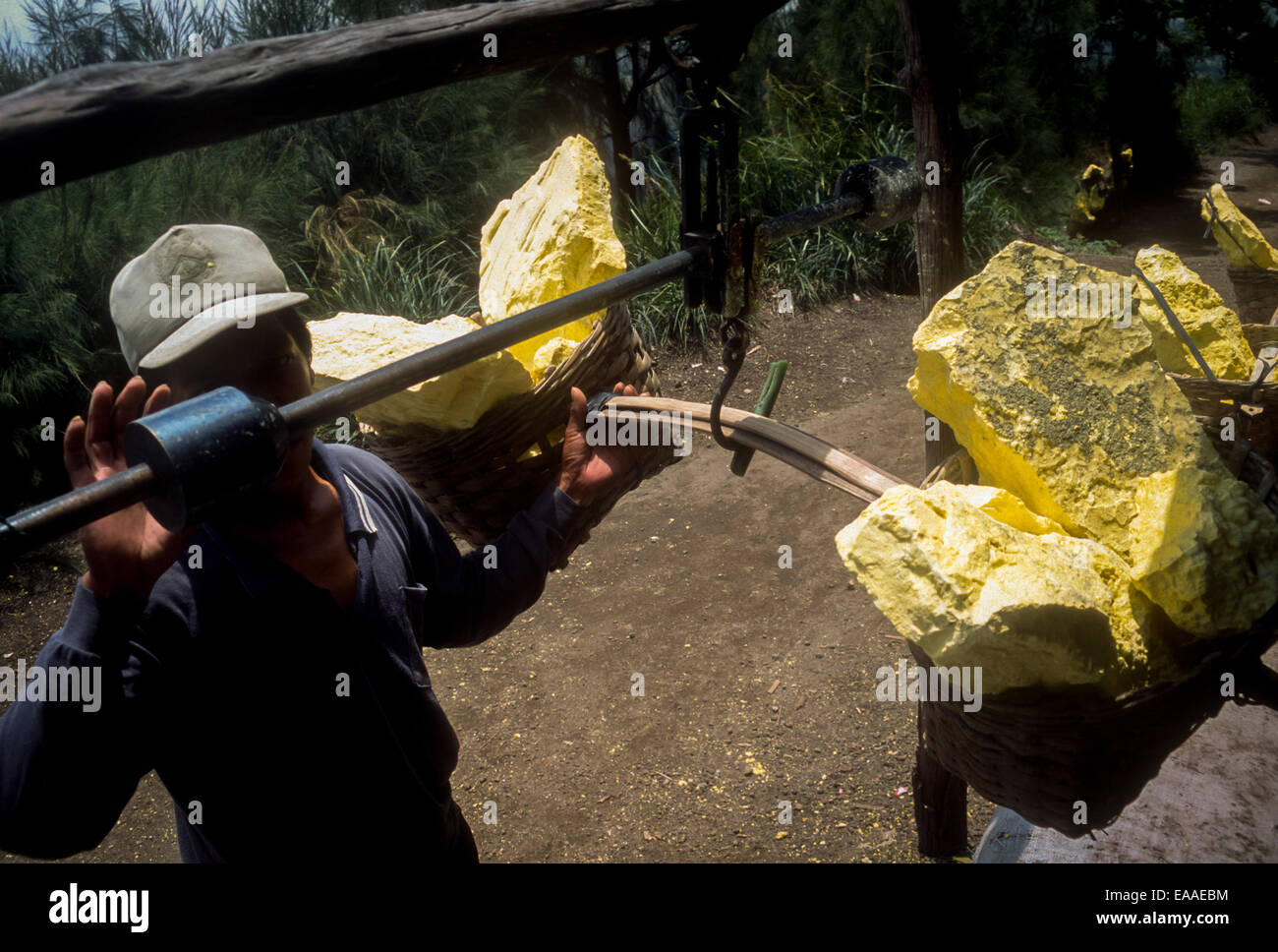 A sulfur miner weighs his load at a checkpoint of Mount Ijen sulfur ...
